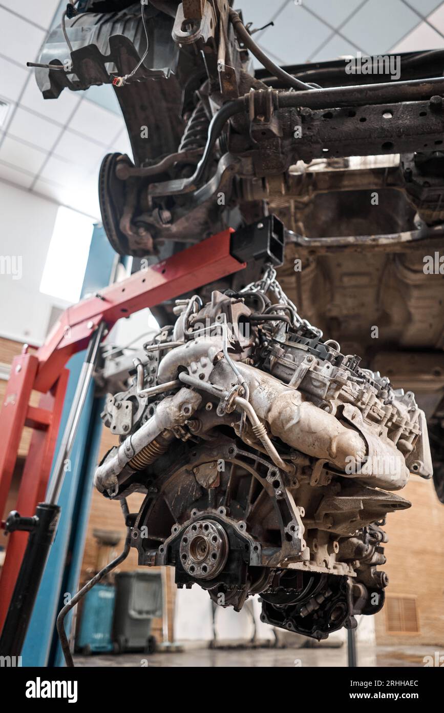 A car mechanic inspects the engine with a flashlight. Engine Block on a ...