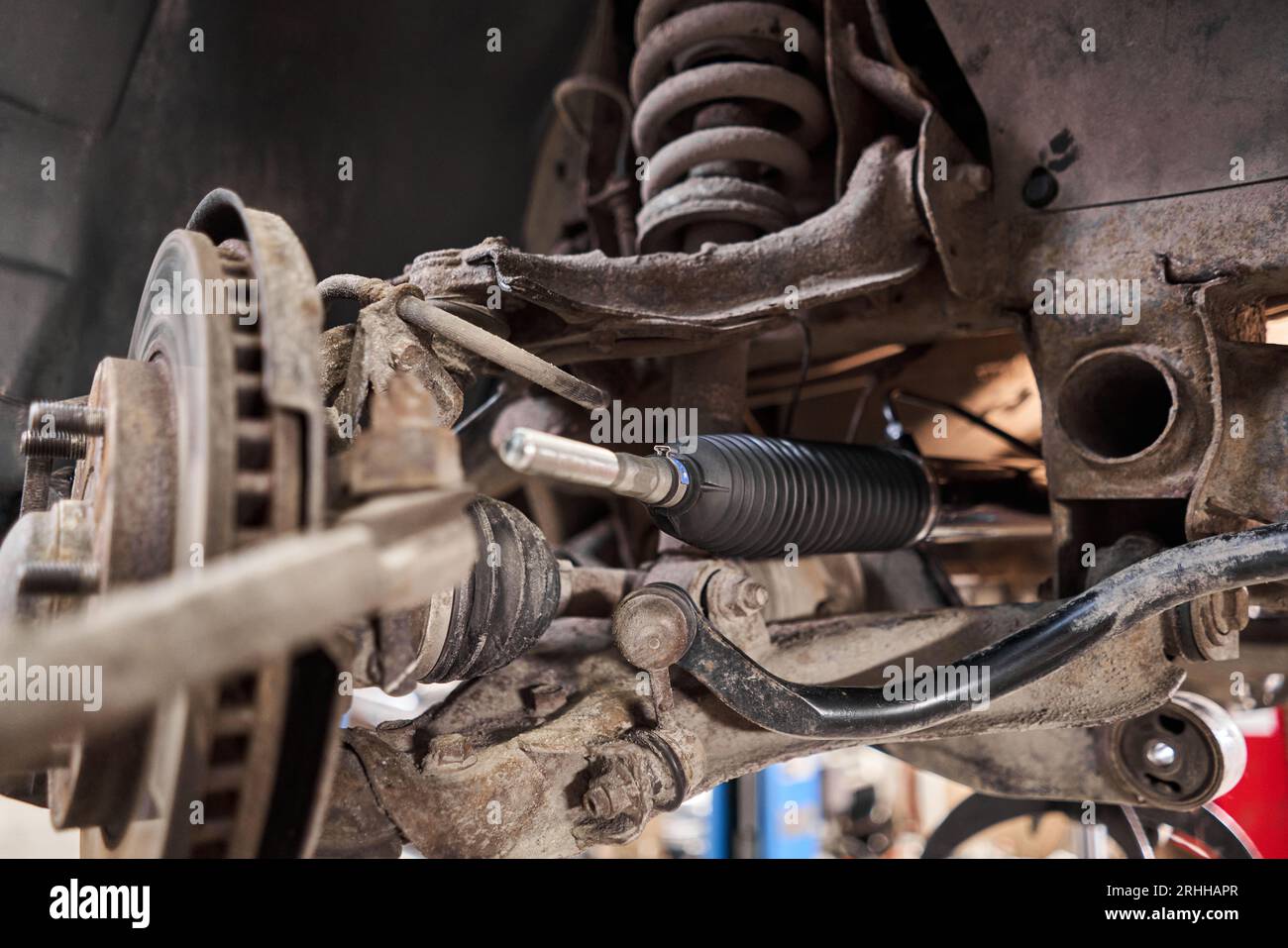 Car mechanic inspecting car steering rod and repair suspension detail ...