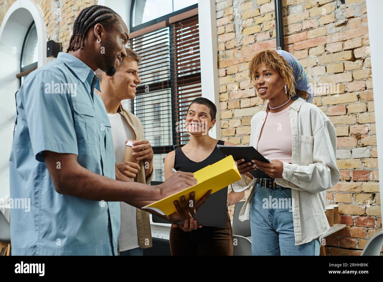 cheerful colleagues discussing project, generation z people, coworking ...