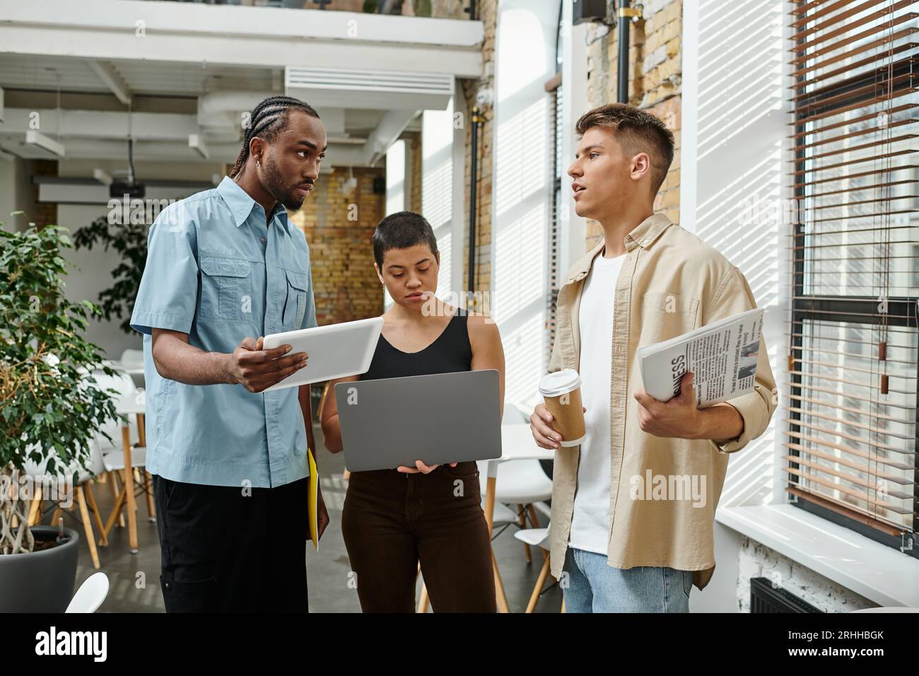 happy interracial coworkers using gadgets, laptop, tablet, digital ...