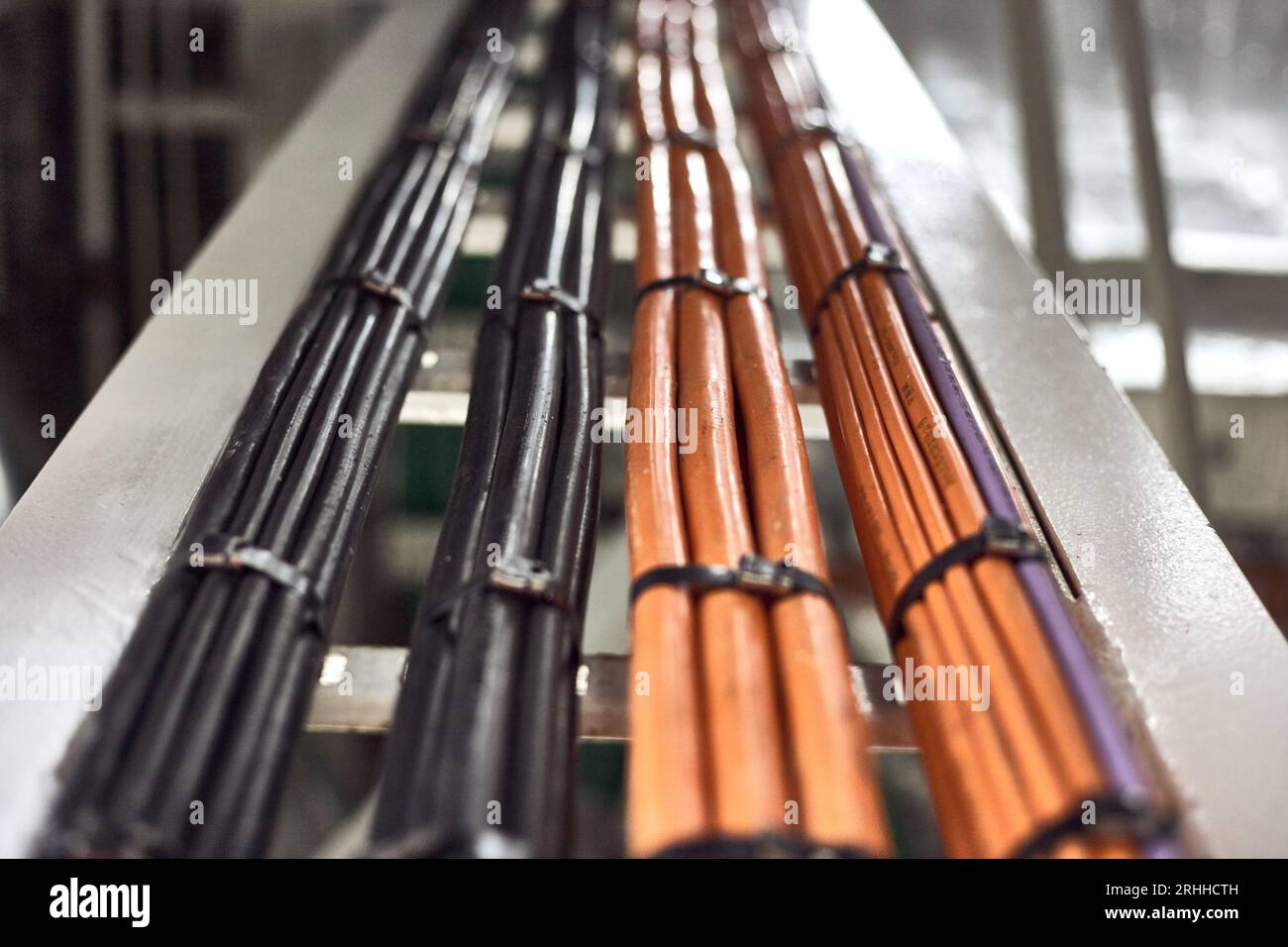 High power black and orange electric cables secured to a cable trunk by ...