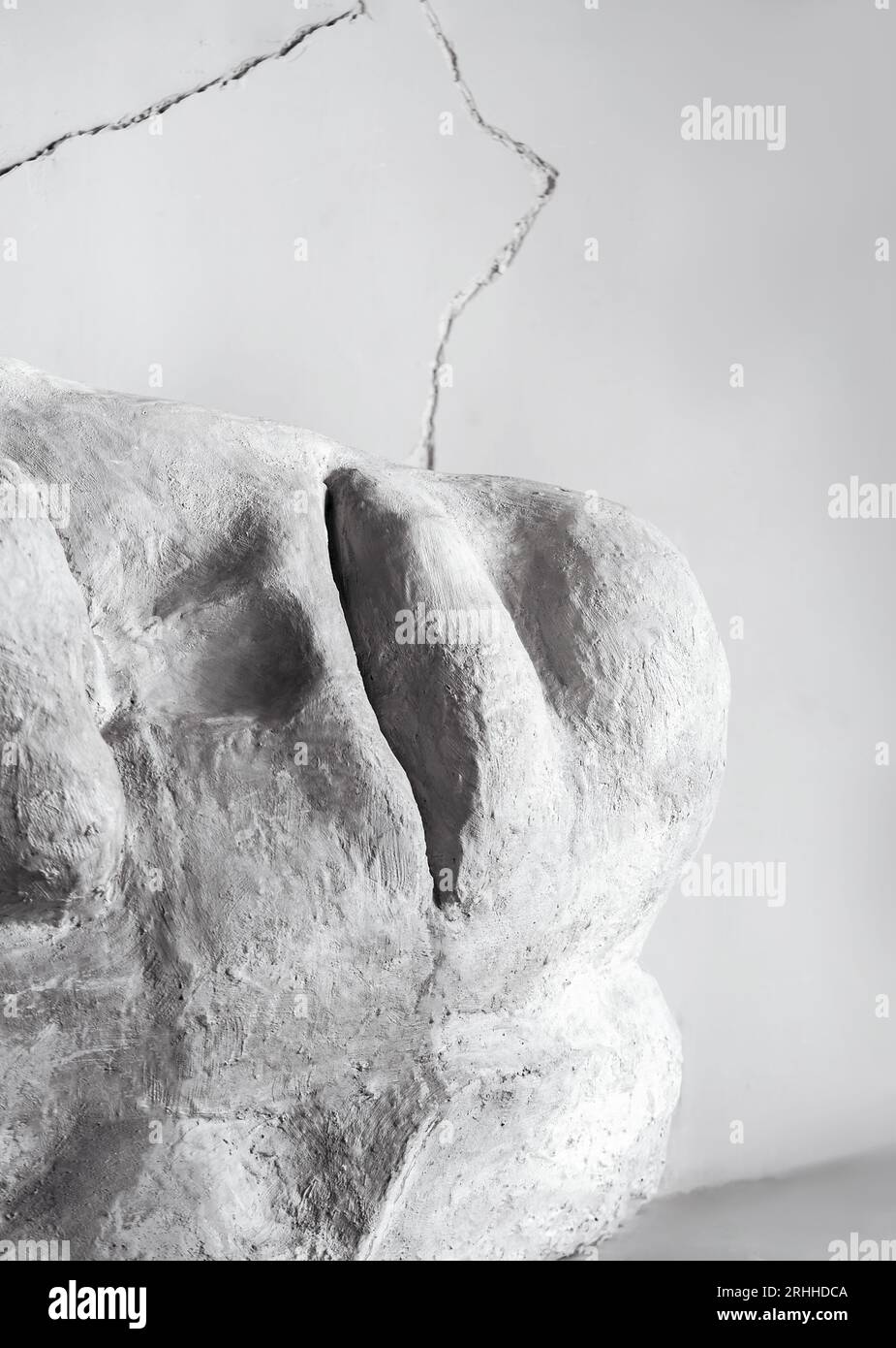 A fragment of plaster human head sculpture against grey background ...