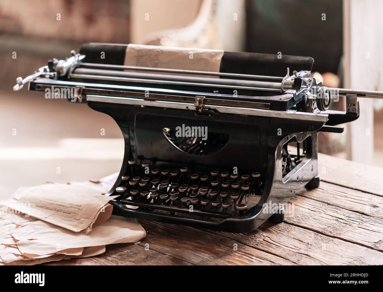 Vintage aged black typewriter with old paper blank on wooden table ...