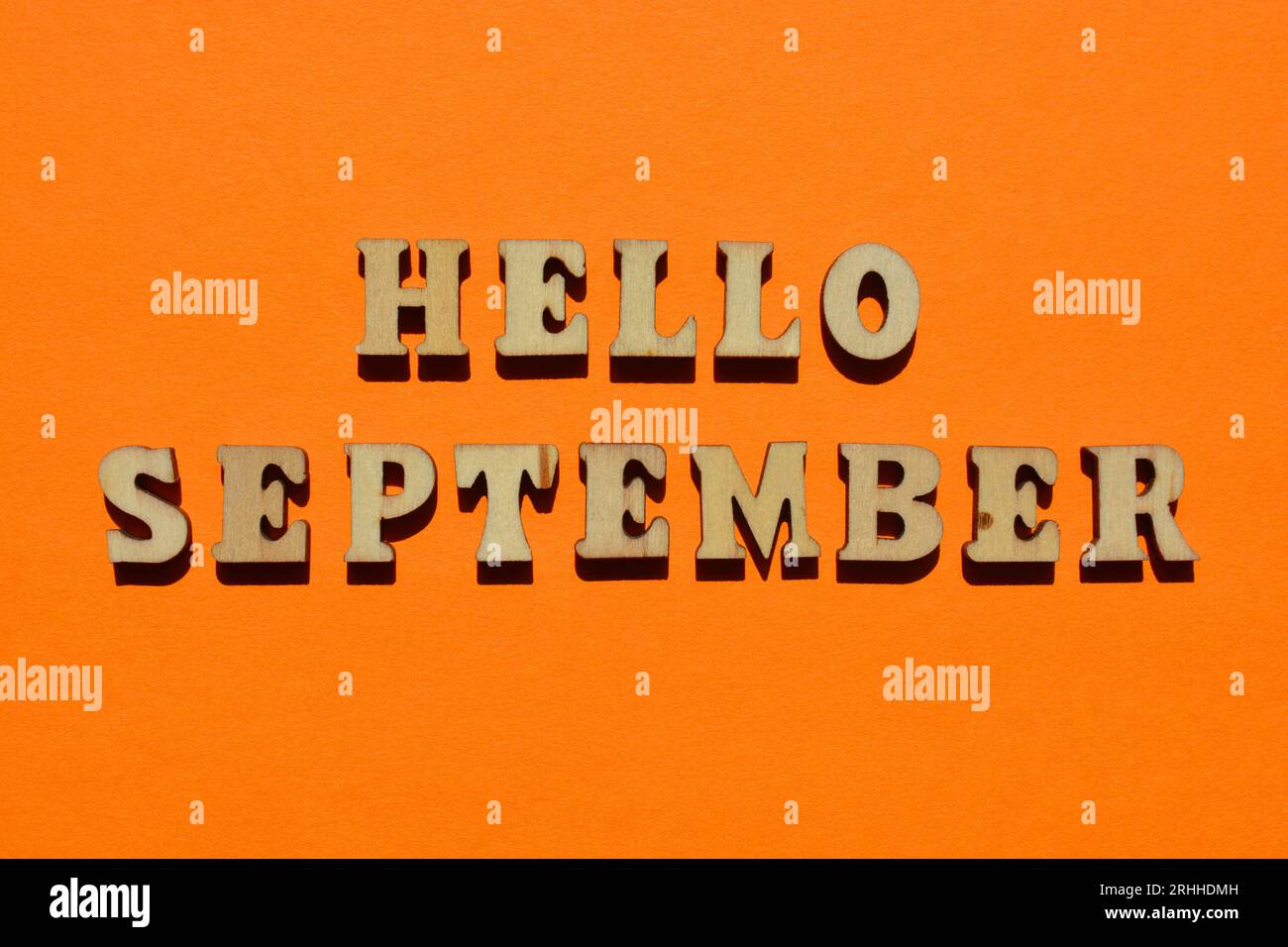 Hello September, words in wooden alphabet letters isolated on orange ...