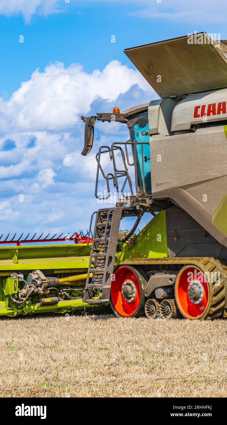 A Claas combine harvester working to harvest the corn on a summer’s day ...