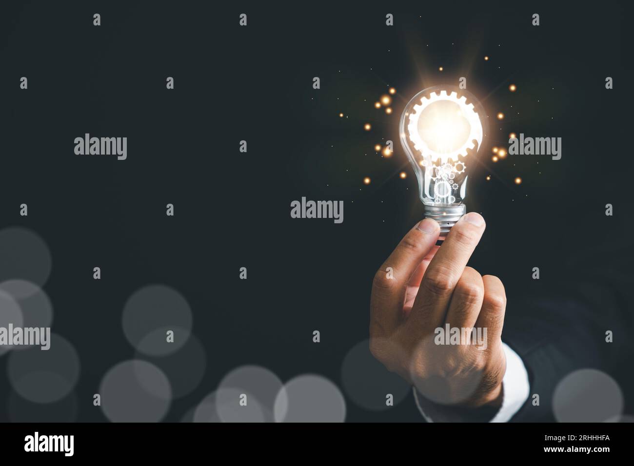 A hand holding a glowing light bulb, signifying the connection between ...