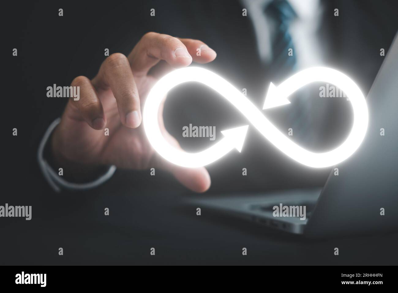 Circular infinity symbol in businessman's hand on dark background Stock ...