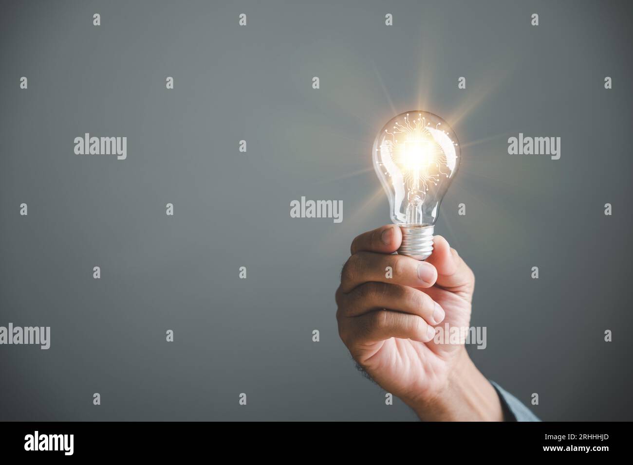 A hand holding a glowing light bulb, signifying the connection between ...