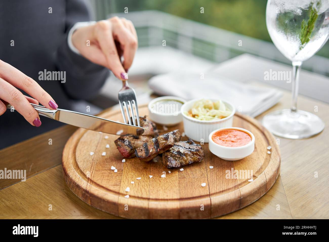 Lunch in a restaurant, a woman eats Pieces of liver cooked on the grill ...