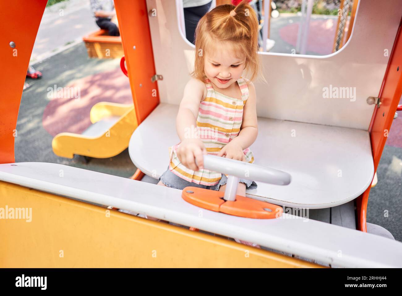 Little girl playing, she is a car driver holding steering wheel on ...