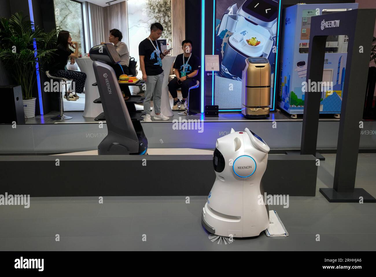 Exhibitors wait for visitors at their booth displaying the robot ...