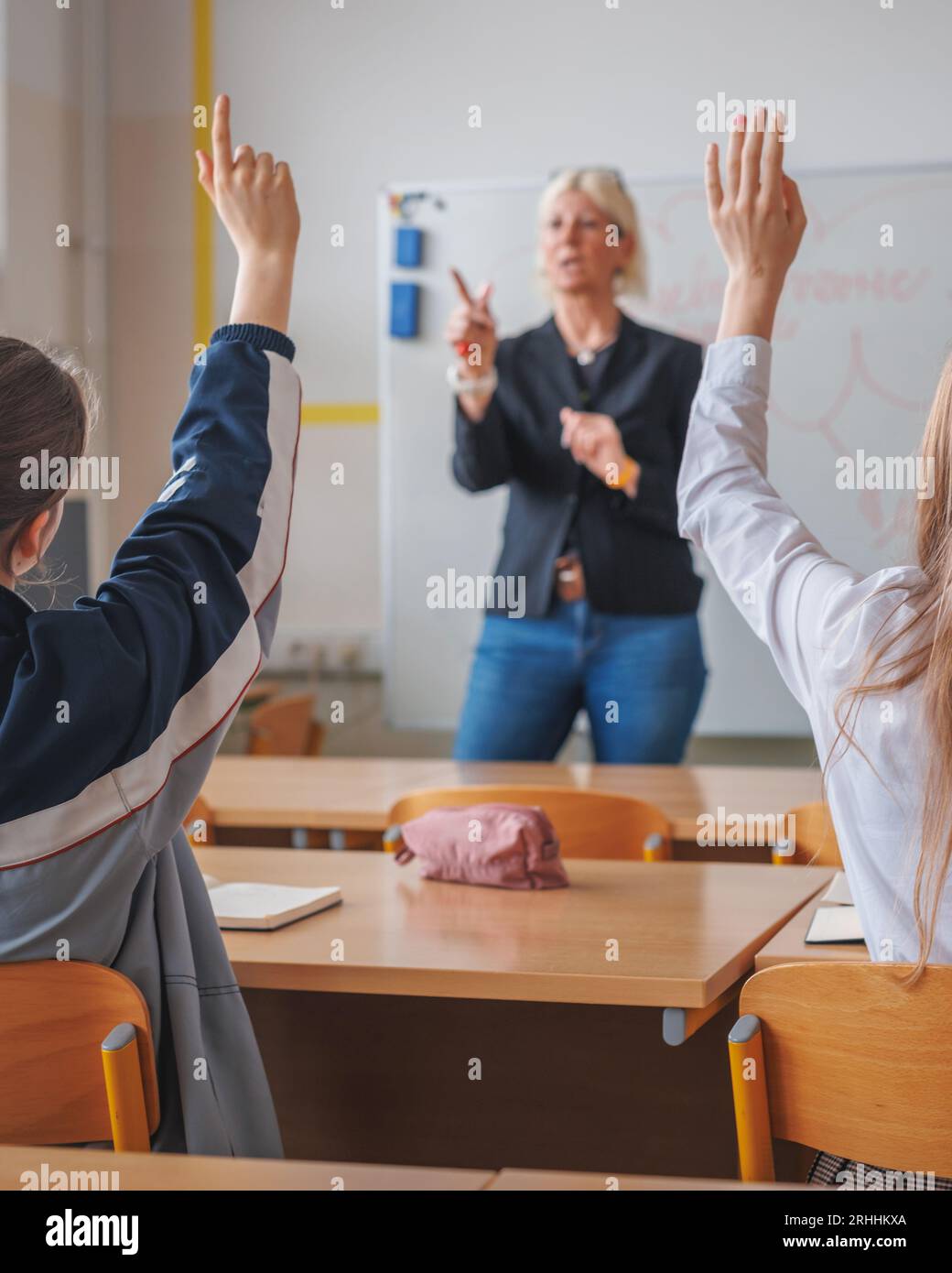 Female student raising her hand and answering a cheerful smiling ...