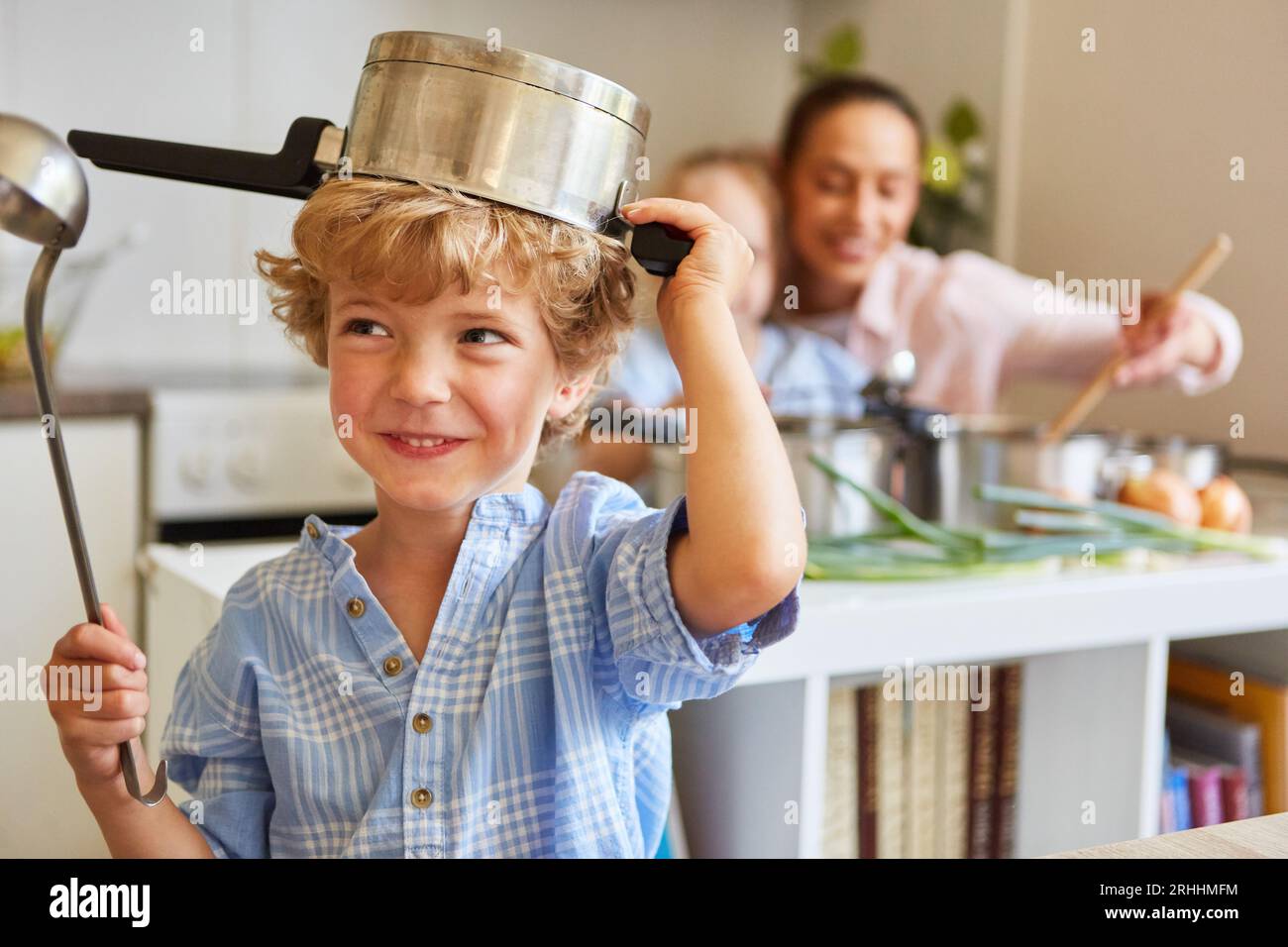 Cute boy playing with cooking pot and ladle in kitchen at home Stock ...