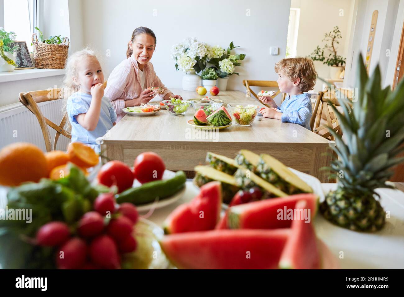 Happy family with mother and two children eating healthy breakfast ...