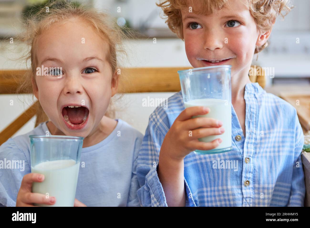 Girl screaming while drinking milk with brother at home Stock Photo - Alamy