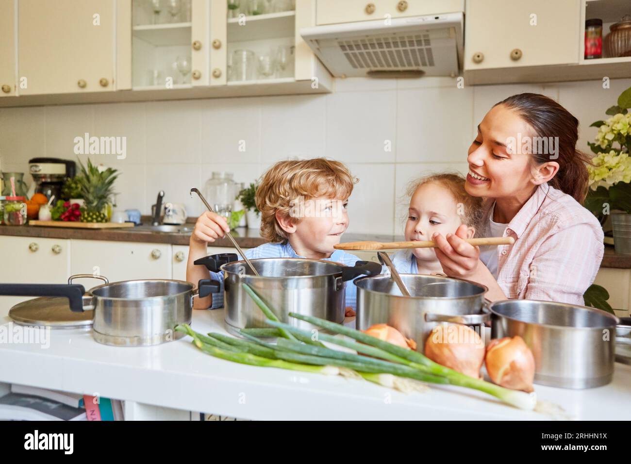 Family cooking lunch together in kitchen with two children Stock Photo ...