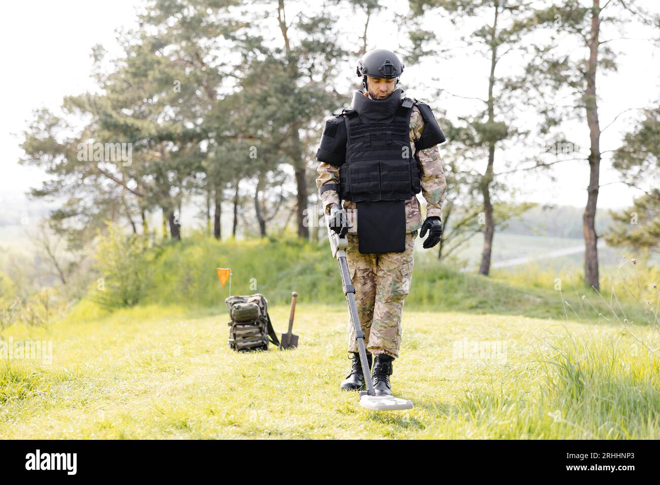 A man in a military uniform and bulletproof vest works in the forest ...