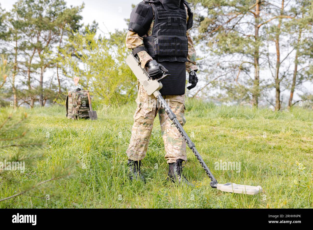 A man in a military uniform and bulletproof vest works in the forest ...