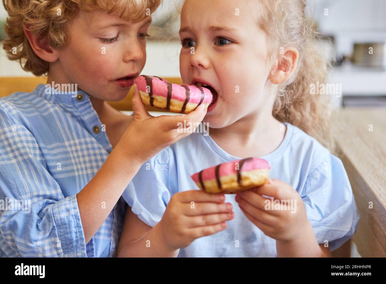 Boy sharing fresh donuts with sister at home Stock Photo - Alamy