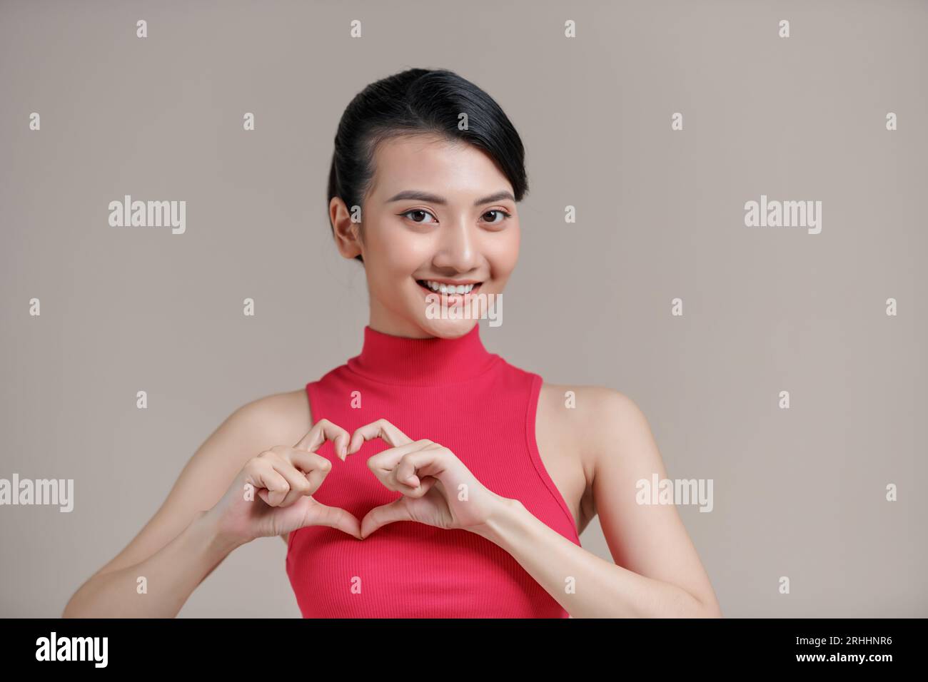 pretty girl showing with her finger heart figure, sending love to her ...