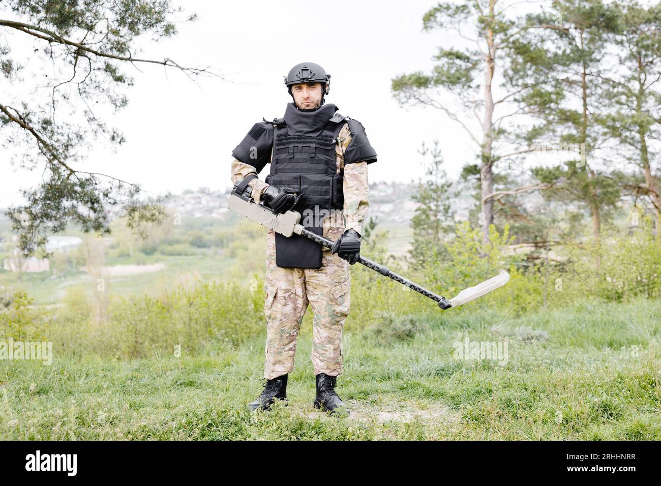 A man in a military uniform and bulletproof vest works in the forest ...