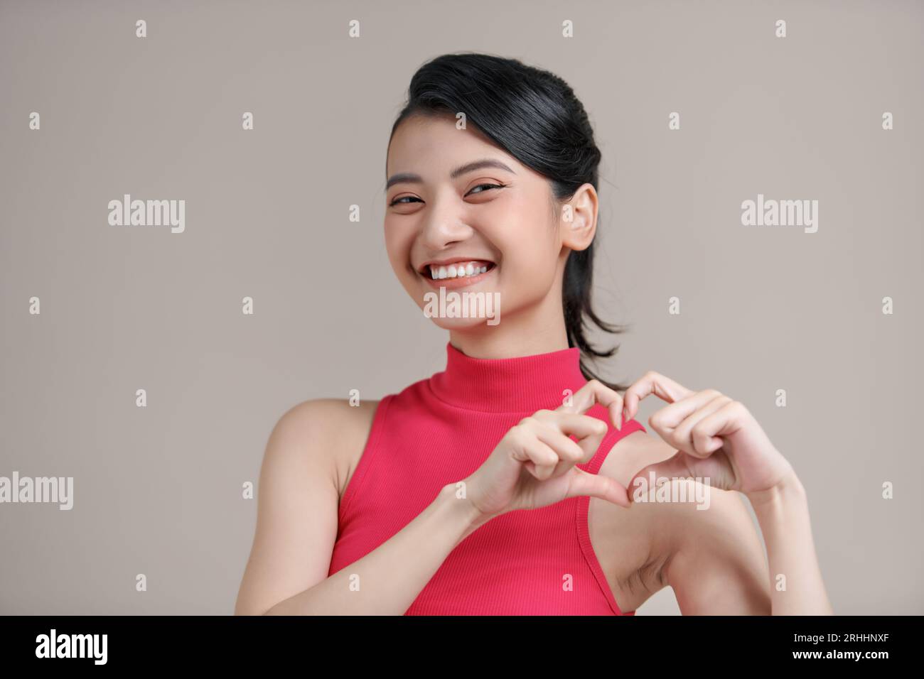 Pretty Romantic Young Asian Woman Making A Heart Gesture With Her