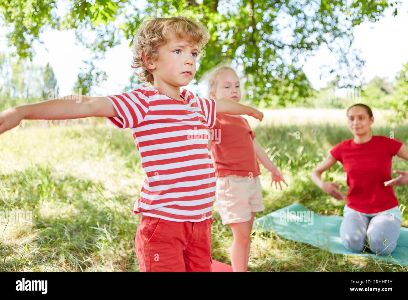 Boy standing with arms outstretched while exercising near family in ...