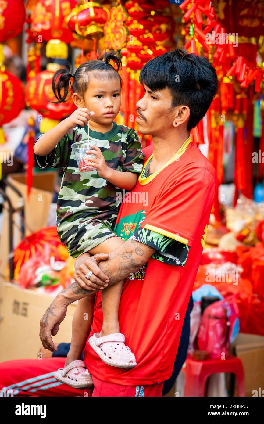 A proud young Thai dad plays with his beautiful little daughter in ...