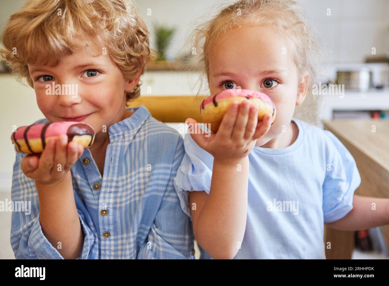 Cute siblings smelling fresh donuts in kitchen at home Stock Photo - Alamy