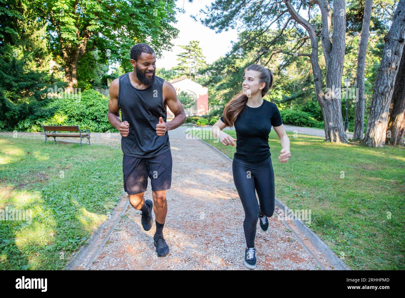 Two athletes during a run smile and look at each other, healthy living ...
