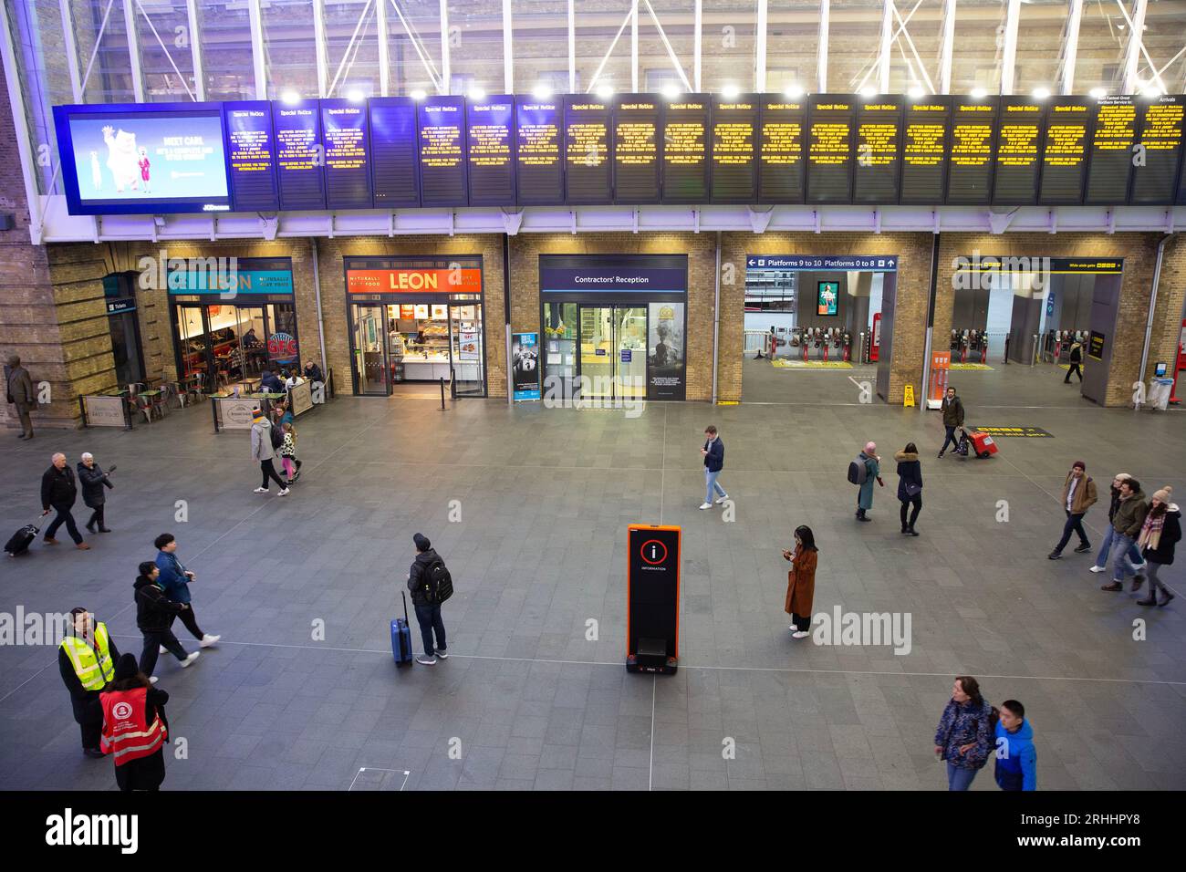 People walk in front of electric timetables at King’s Cross Station in ...