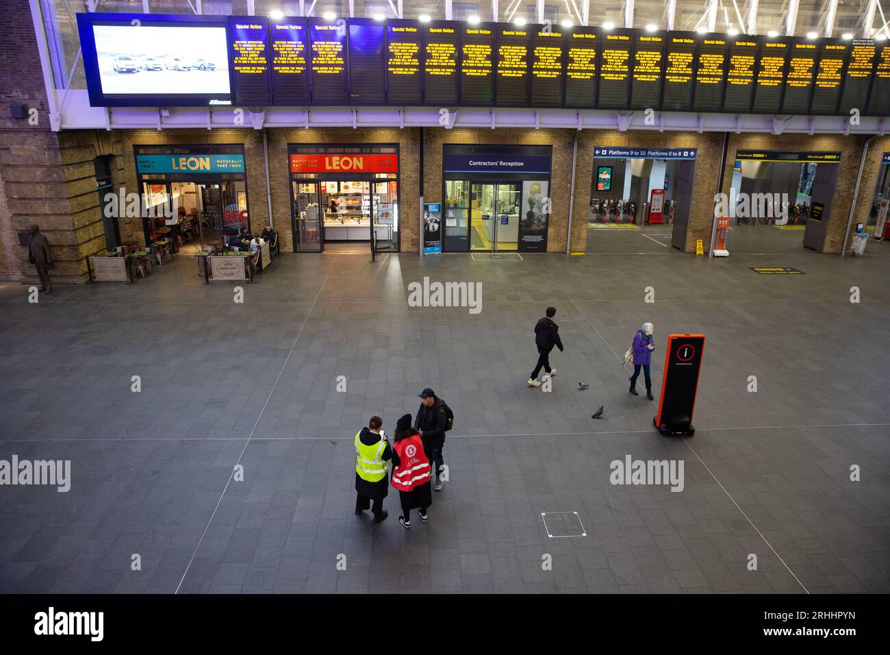 Members of the staff stand at a quiet King’s Cross Station in London ...