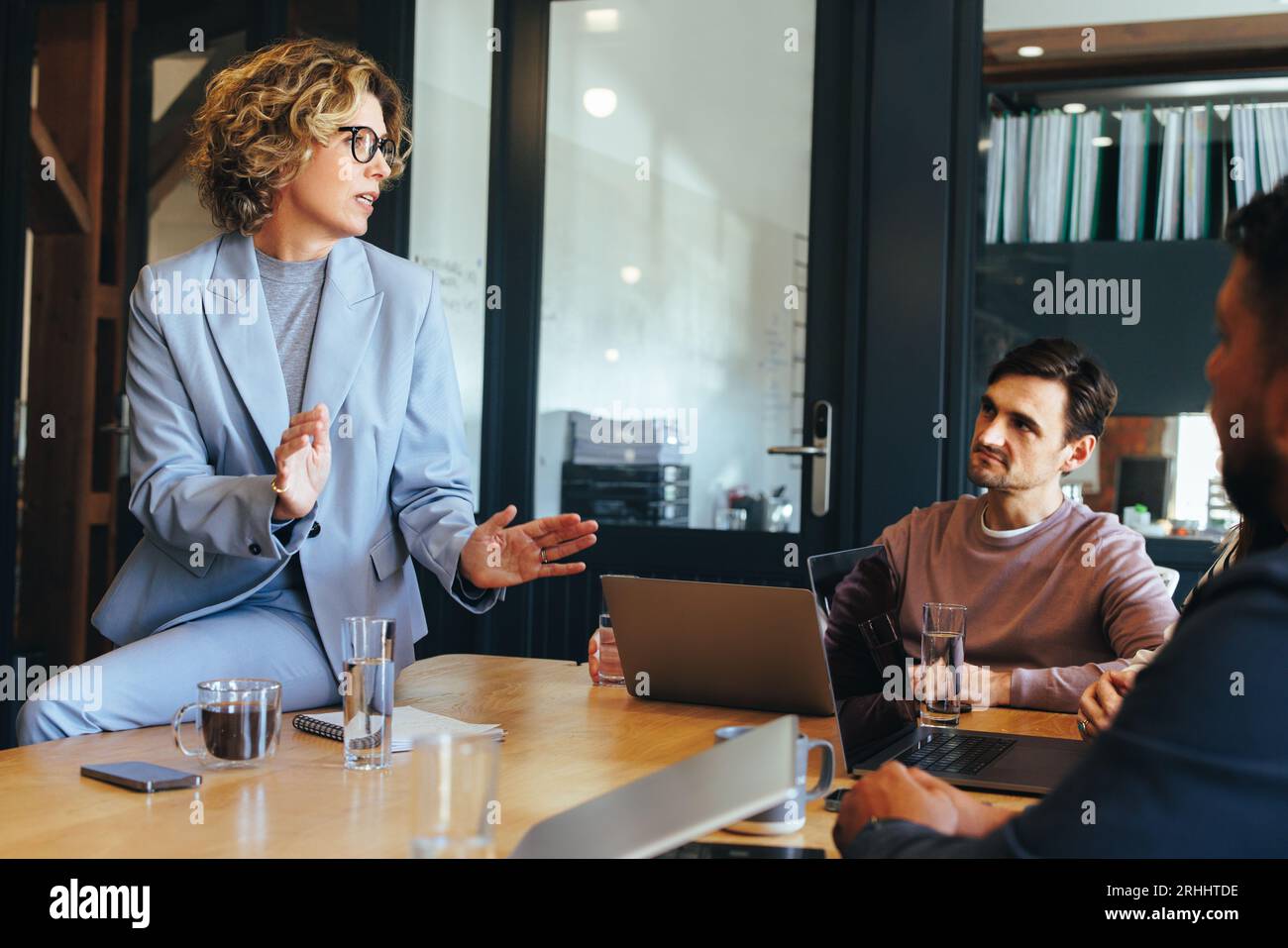 Female team leader having a discussion with her colleagues in an office ...