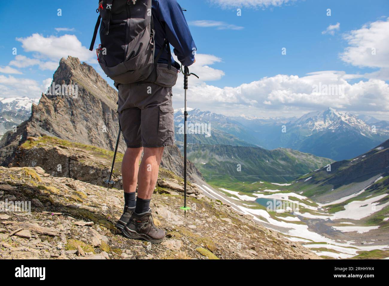 legs of a hiker wearing short and hiking shoes standing at the top of ...