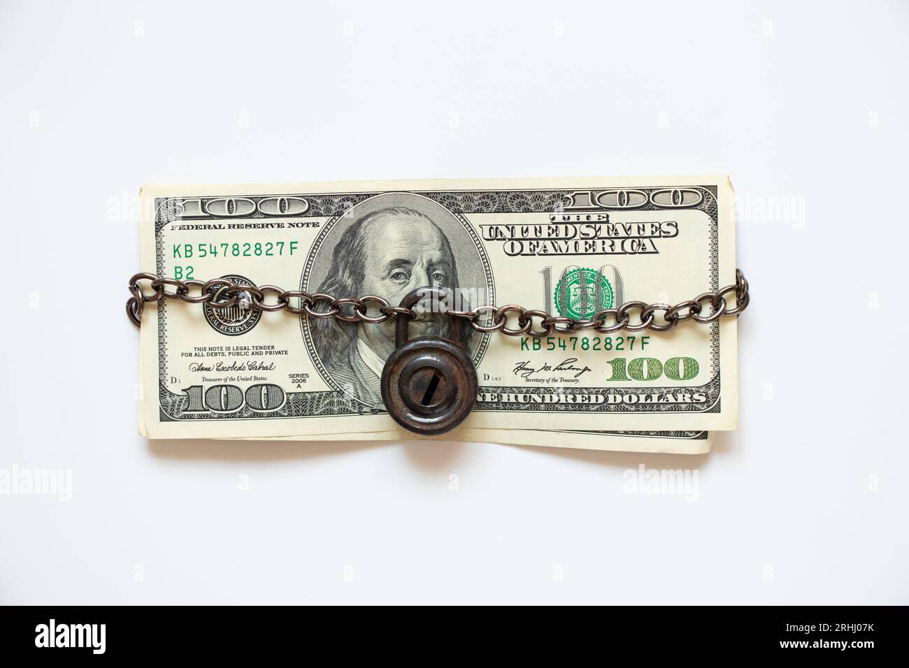 One hundred dollars on a chain under lock and key on a white background ...