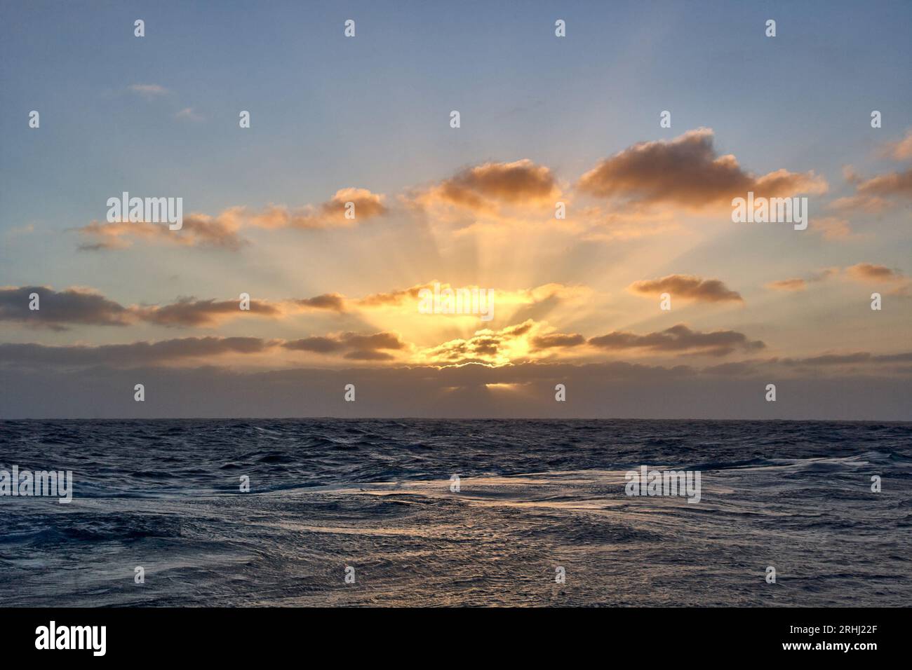 Beautiful golden sunset in the sea with blue waves Stock Photo - Alamy
