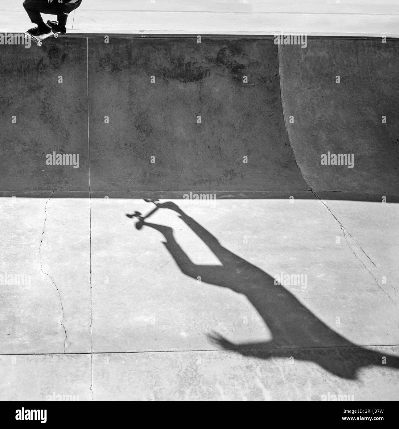black and white silhouette shadow of a skateboarder at a skatepark ...