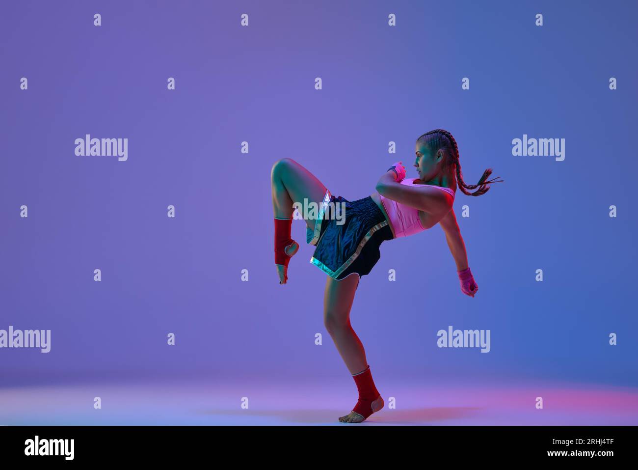 Dynamic photo of sportive teen girl, mma fighter in sportswear training ...