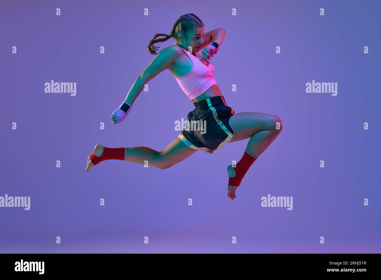 Kick in a jump. Teen girl, mma athlete in motion, training against ...