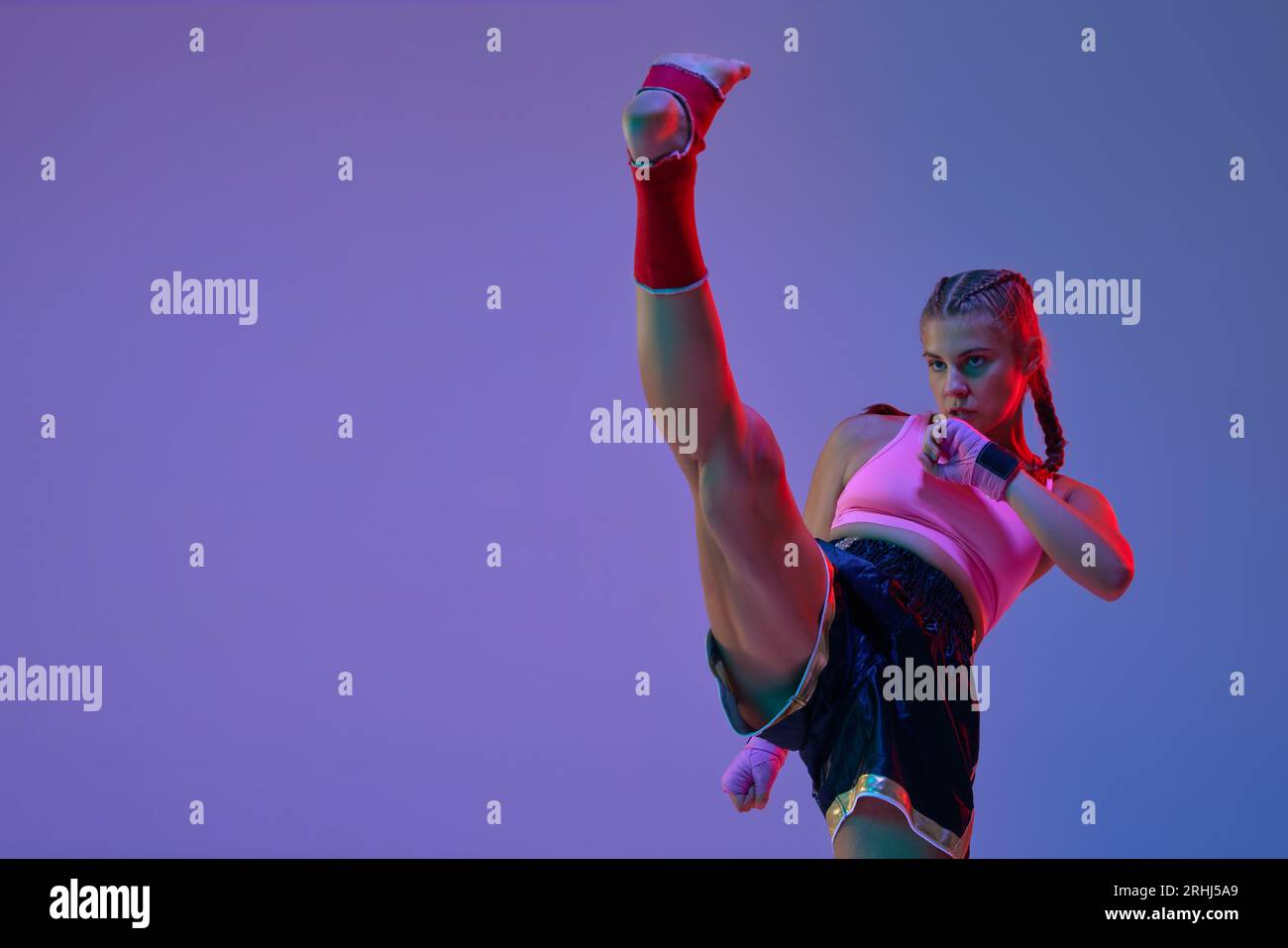 Leg kick. MMA fighter, teen girl training, fighting against purple ... Leg kick. MMA fighter, teen girl training, fighting against purple ...