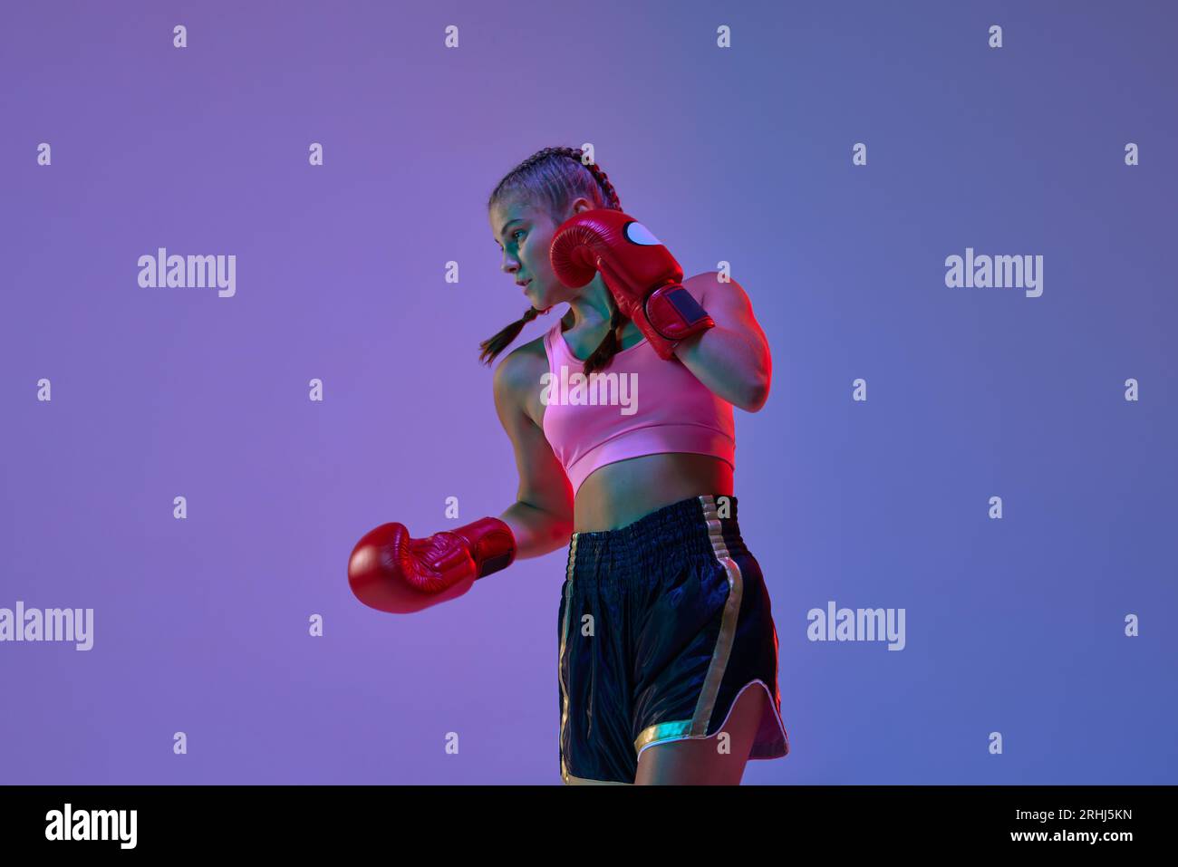 Teen athletic girl, MMA fighter in motion, training kicks against ...