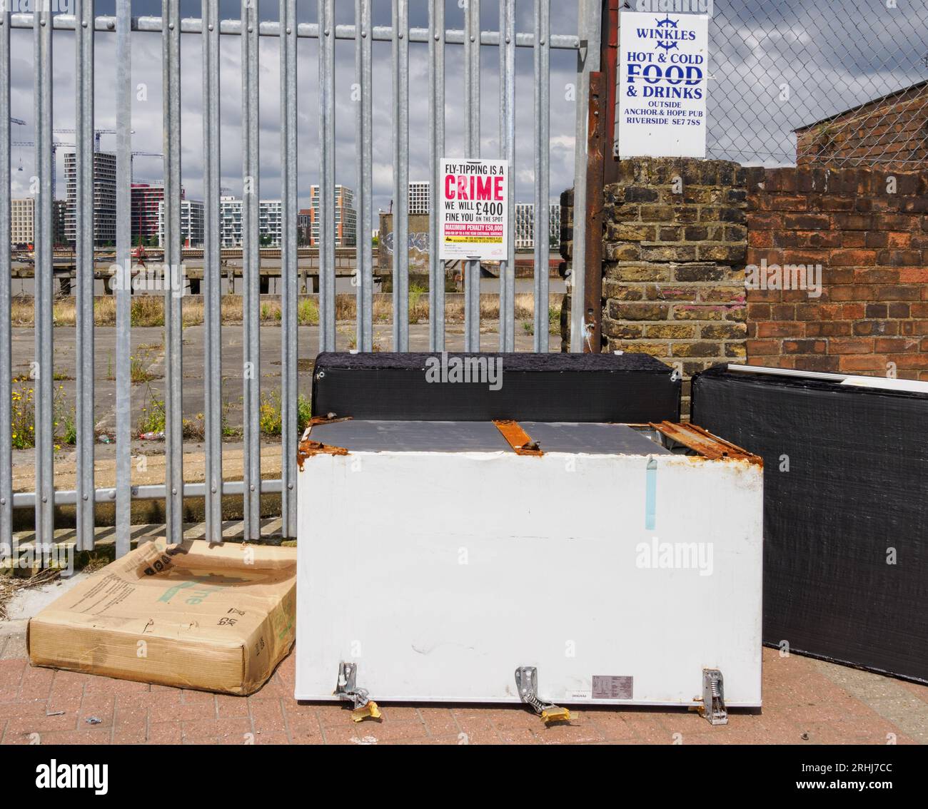 Fly tipping underneath a sign warning that fly tipping is a crime in a ...