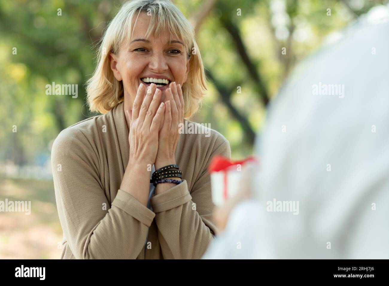 husband take gift to surprised wife in park, old love couple in ...