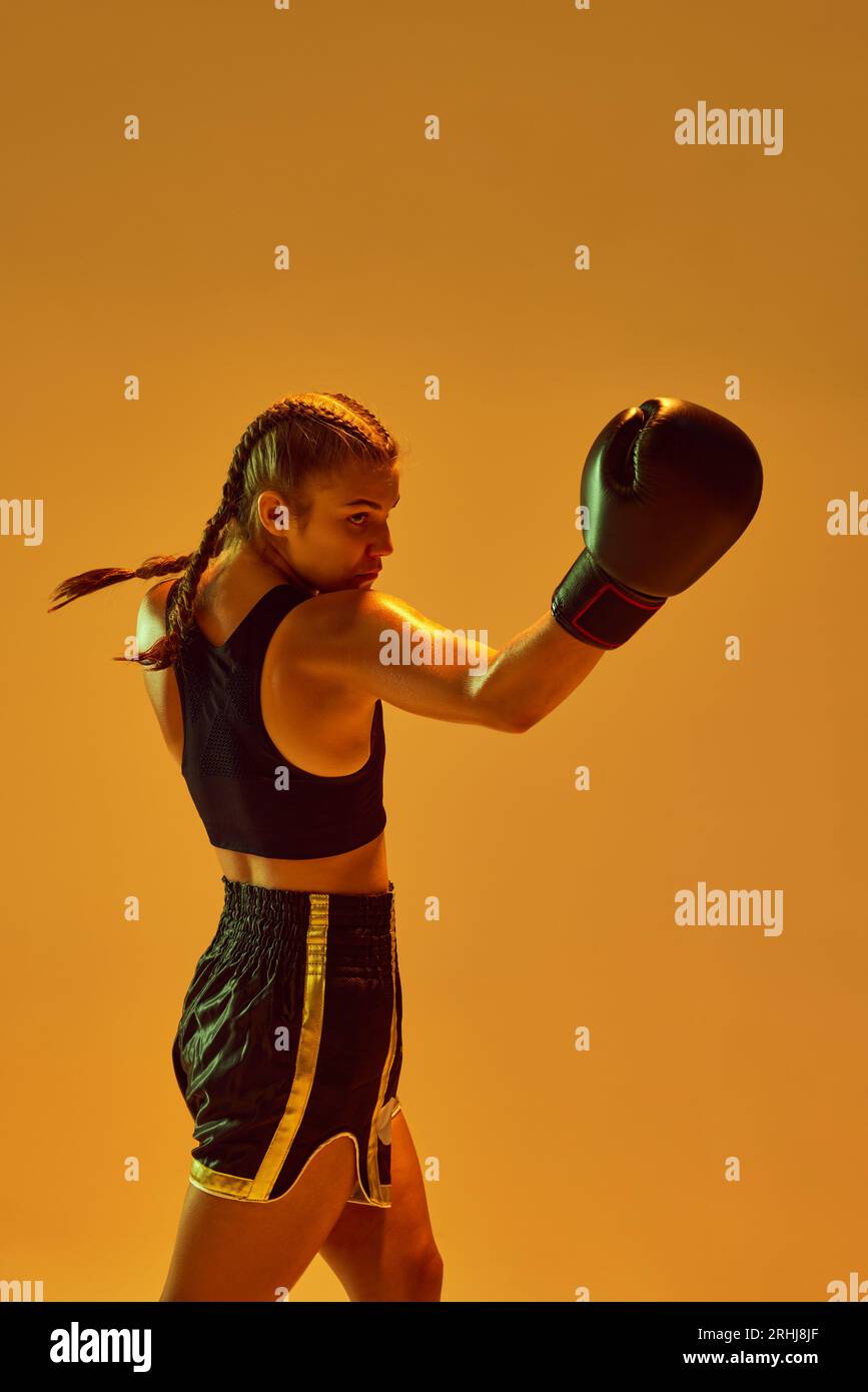Sportive teen girl, MMA athlete in uniform and boxing gloves, training ...