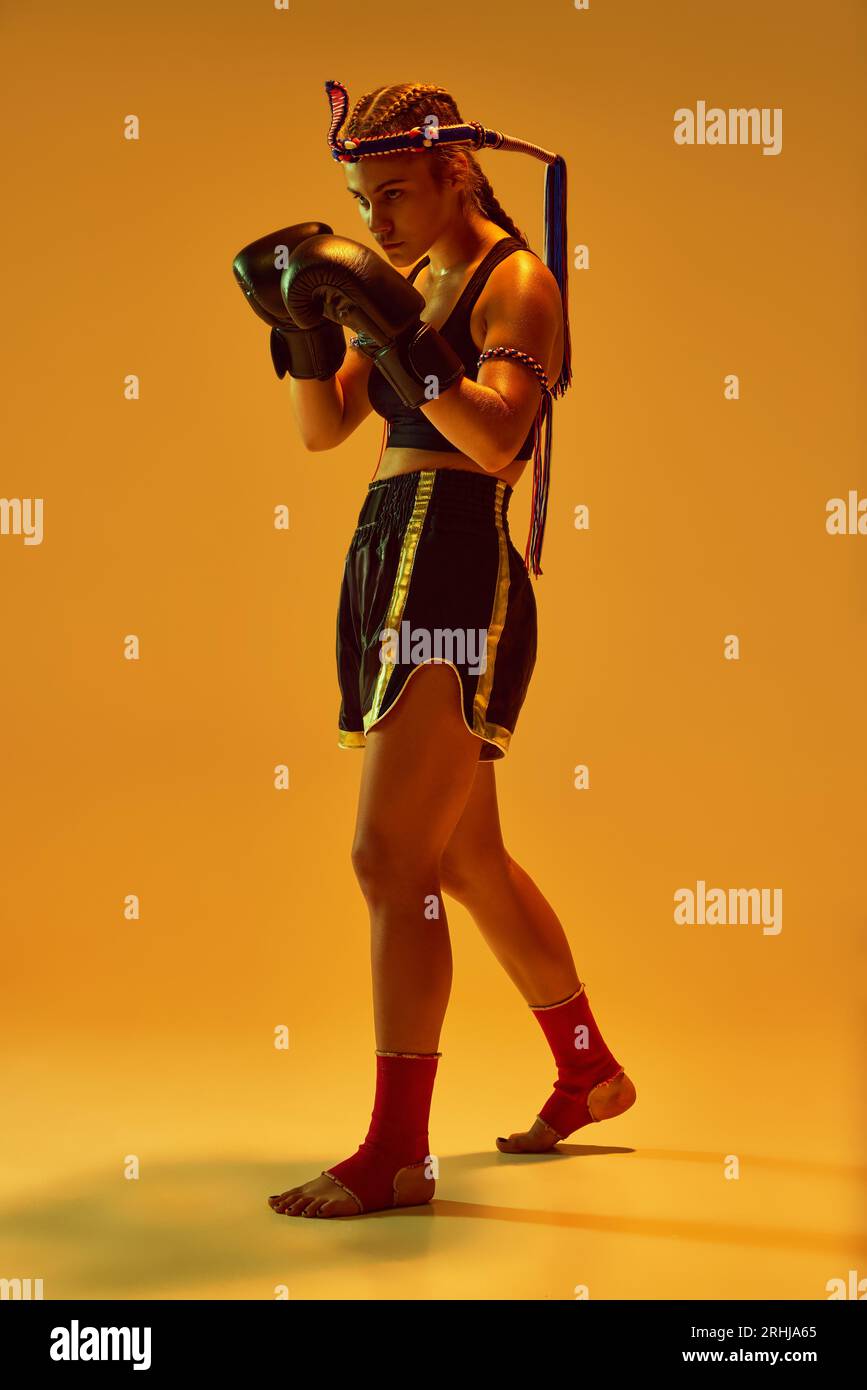 Teen girl, MMA fighter in uniform and boxing gloves, standing in ...