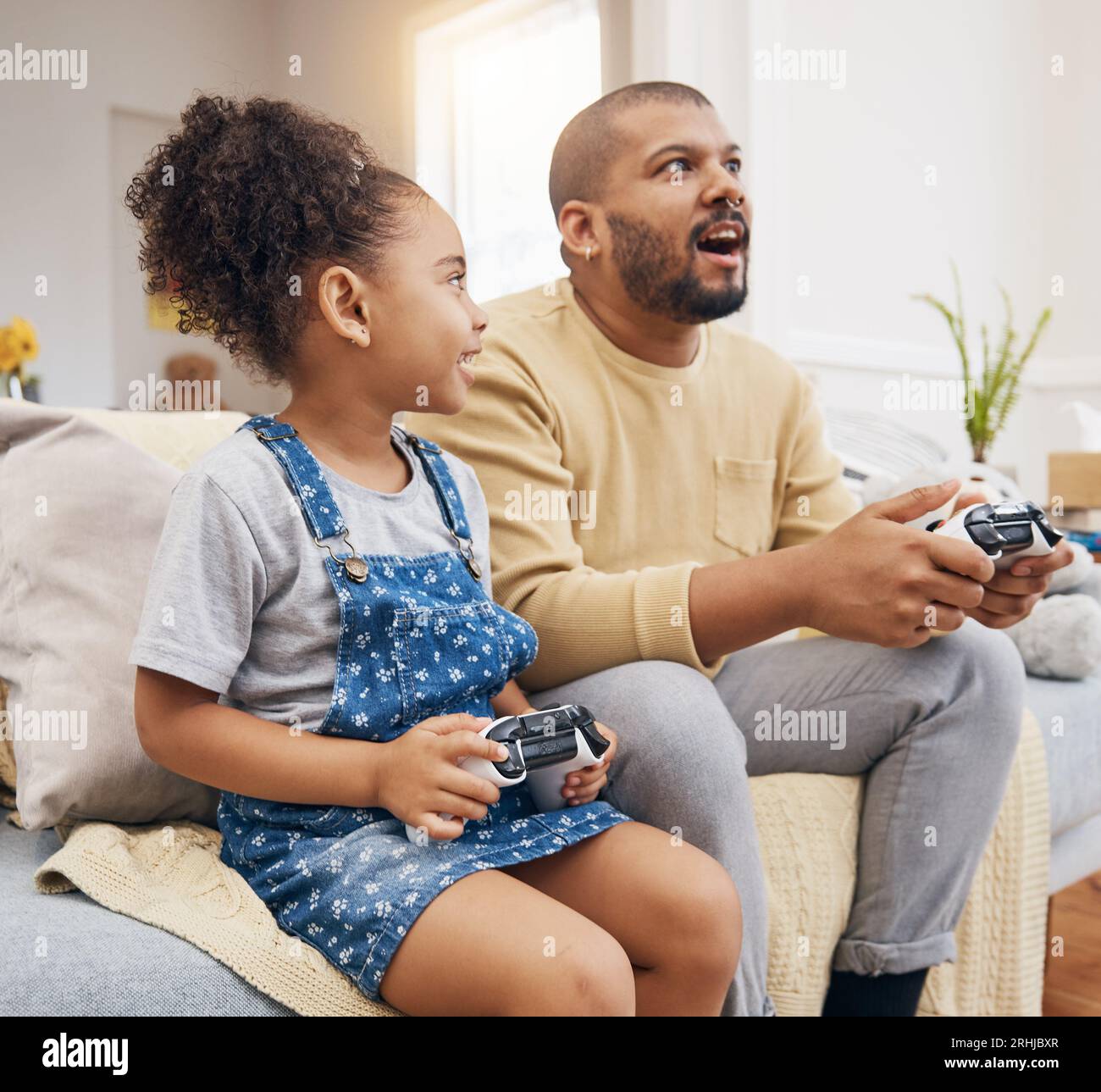 Father, daughter and gaming controller on sofa with challenge, press ...