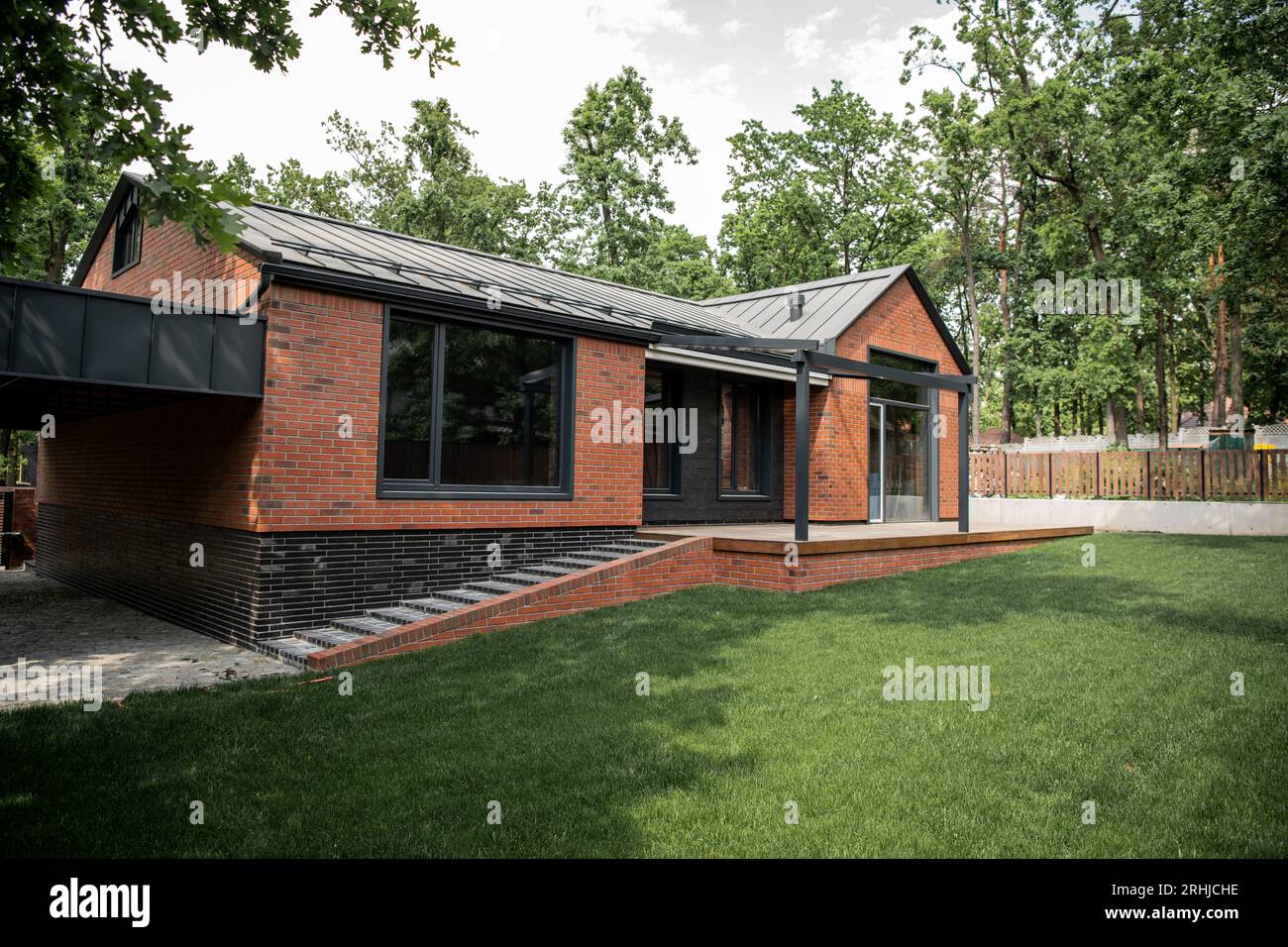 modern brick house with large windows, green lawn, cottage town Stock ...