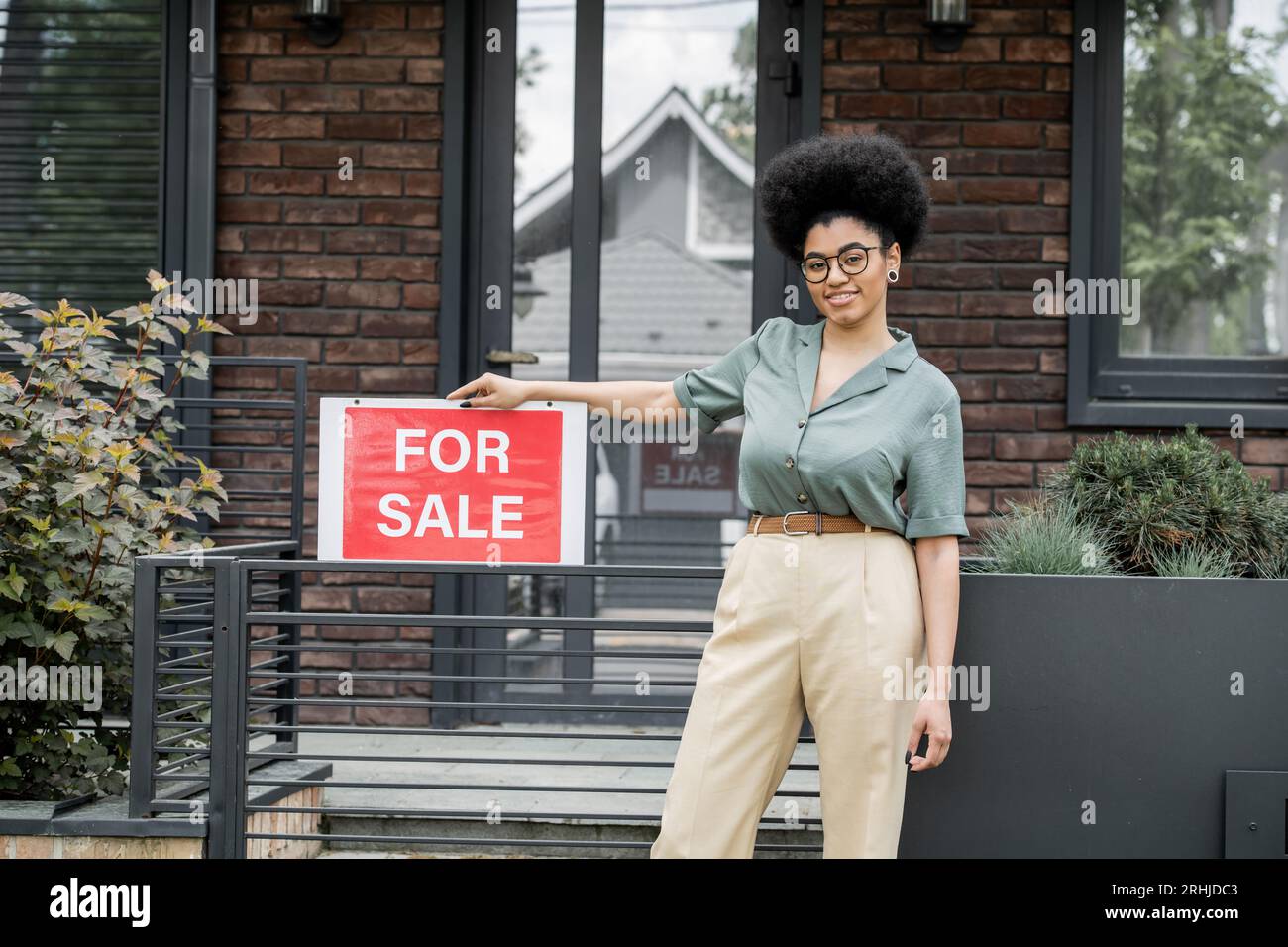 optimistic african american property agent standing with for sale ...