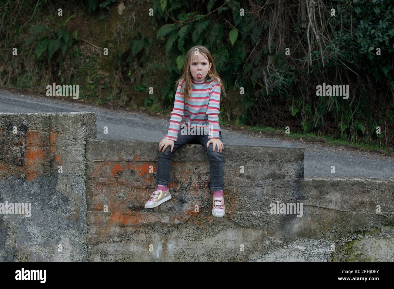 Mischievous child girl grimacing outdoor Stock Photo - Alamy