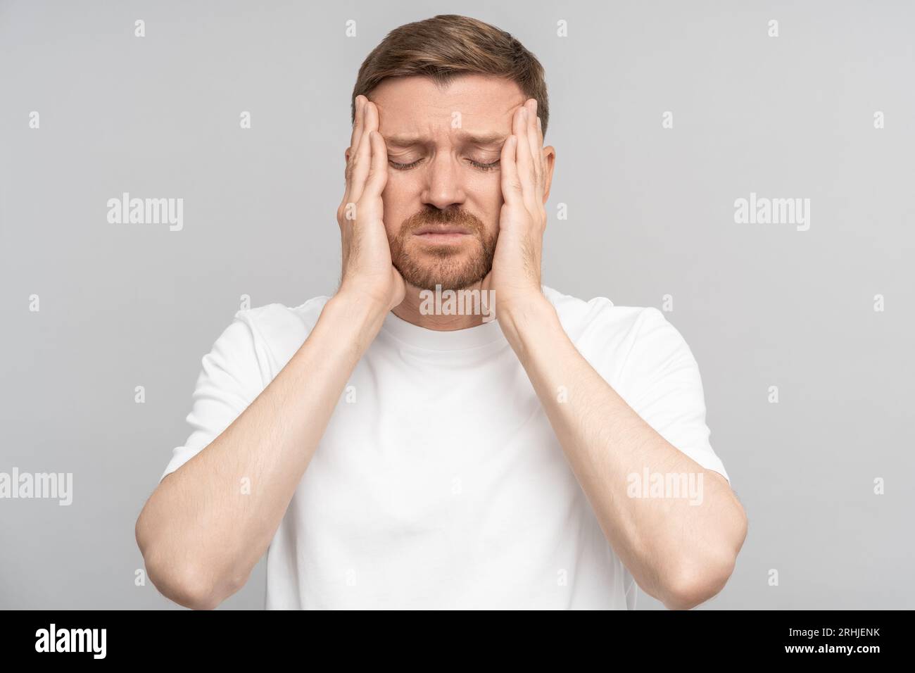 Tired man holds his head suffering from pain. Headache, migraine ...